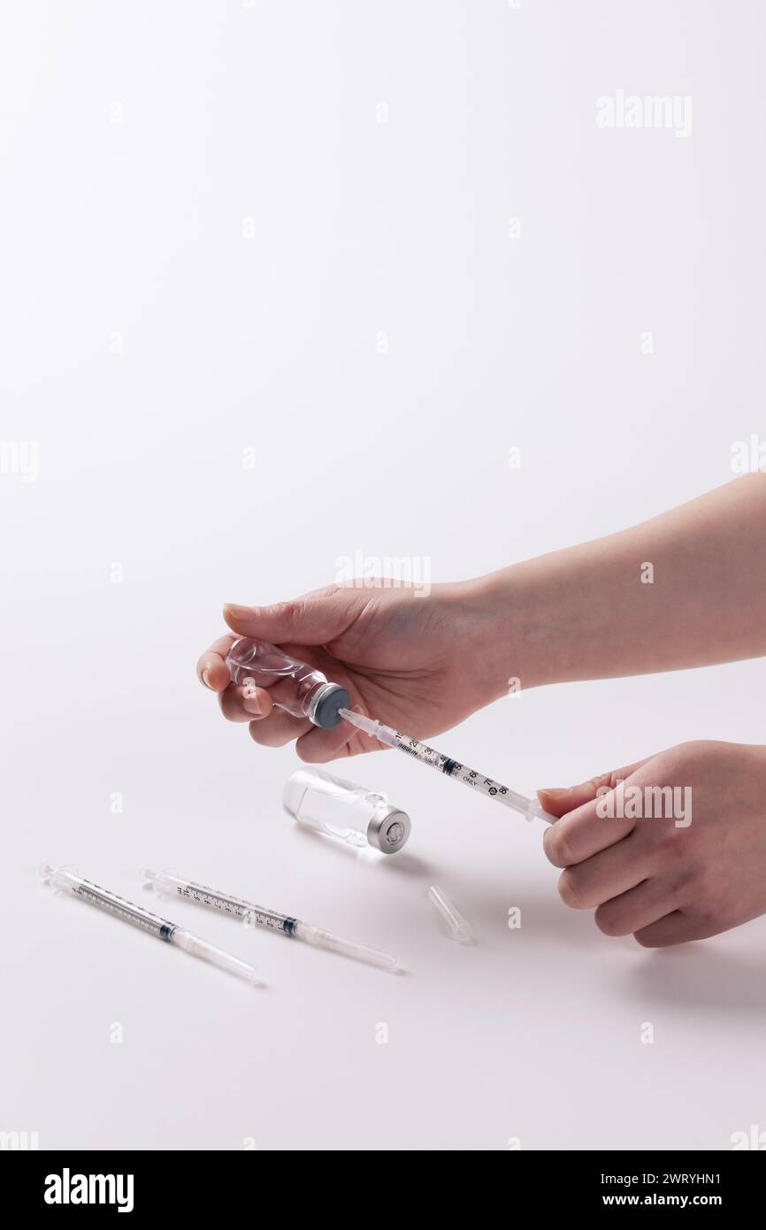 putting a syringe in an injection bottle Stock Photo - Alamy