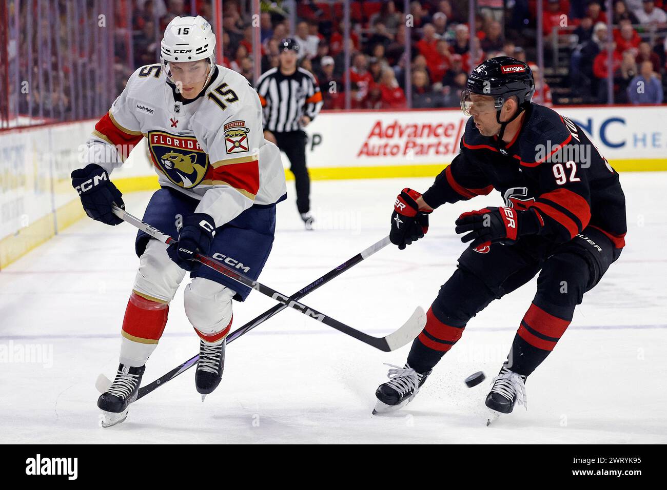 Florida Panthers' Anton Lundell, left, moves the puck past Carolina ...