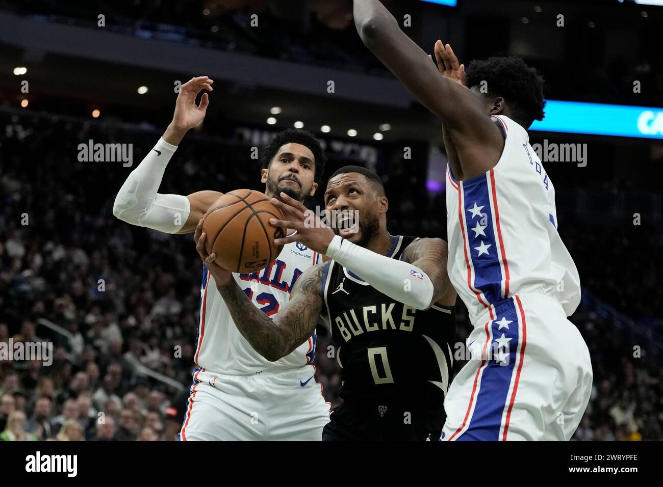 Milwaukee Bucks' Damian Lillard is fouled shooting between Philadelphia ...