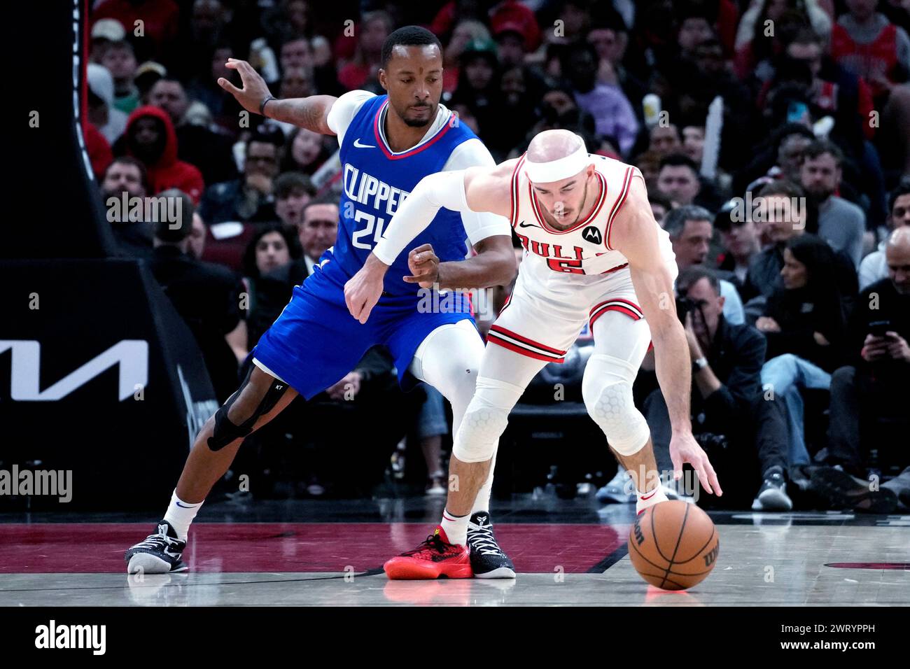 Chicago Bulls guard Alex Caruso, right, drives as Los Angeles Clippers ...