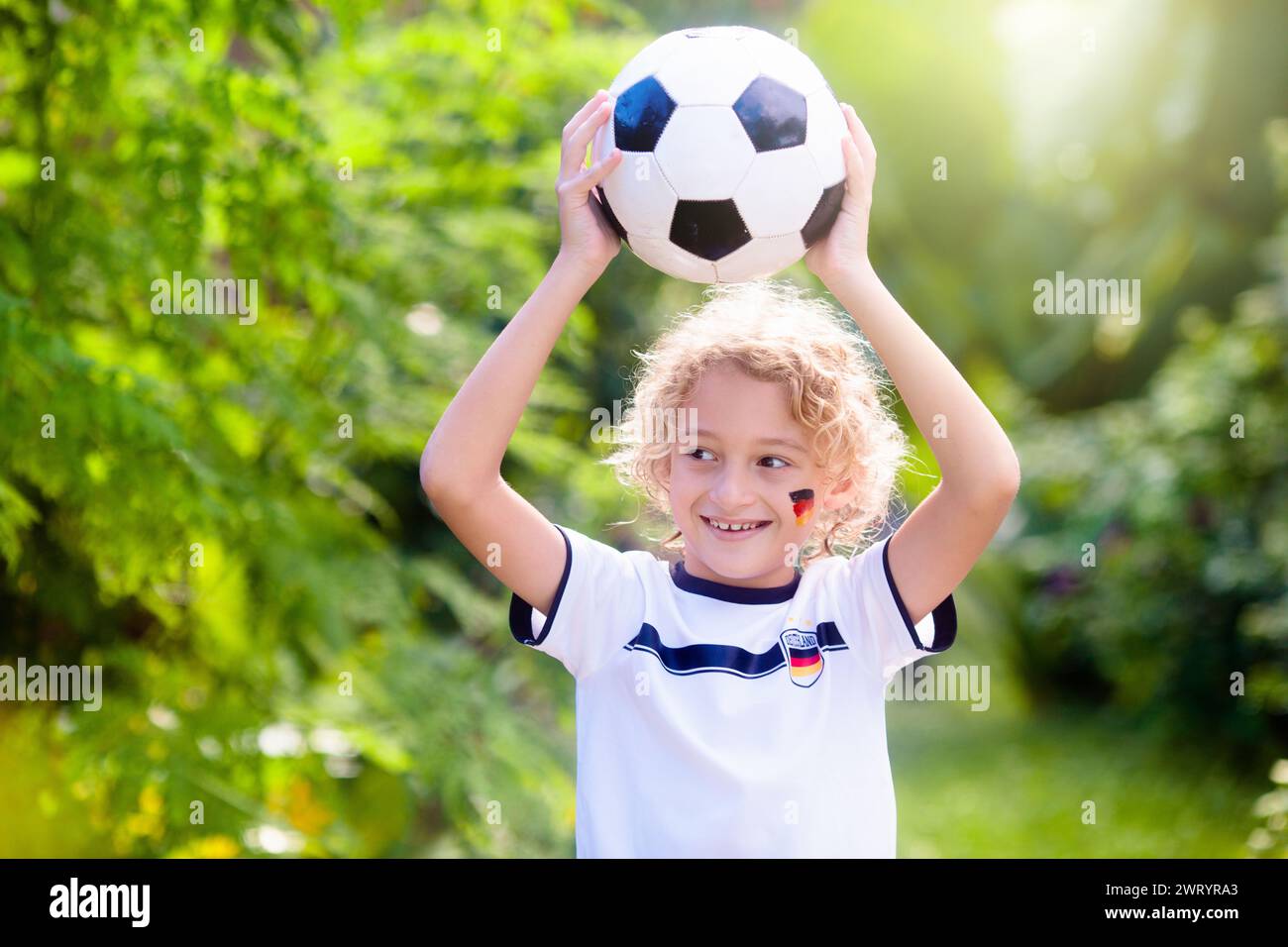 Kids play football on outdoor field. Germany team fans with national ...