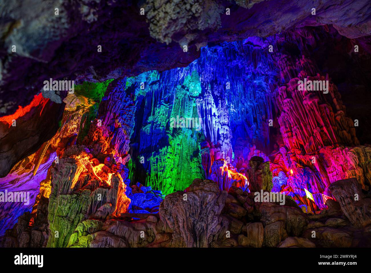 Inside the cave. Stalactites, stalagmites, colored light. Beautiful ...