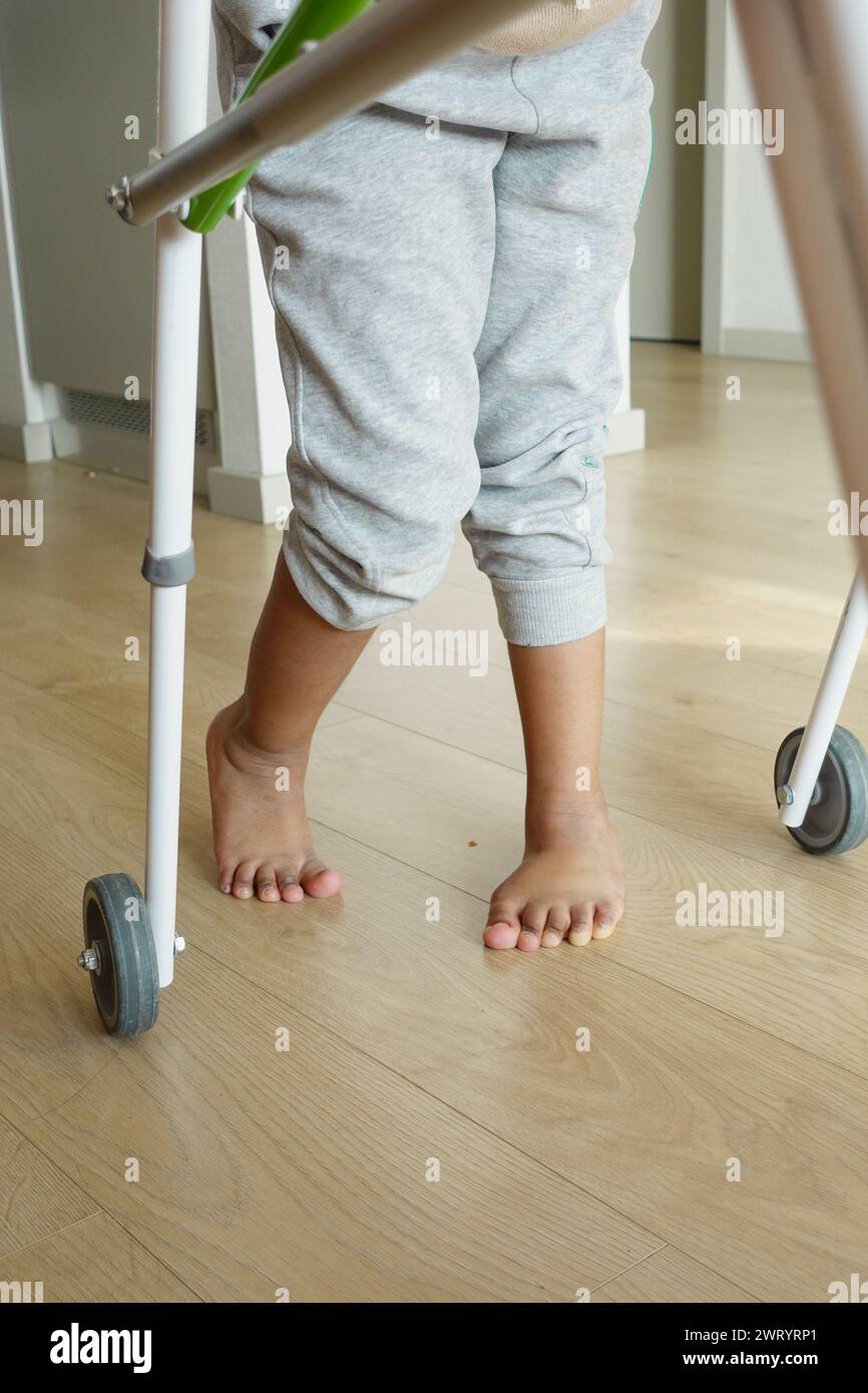 child with walking frame and knee orthosis indoor Stock Photo - Alamy