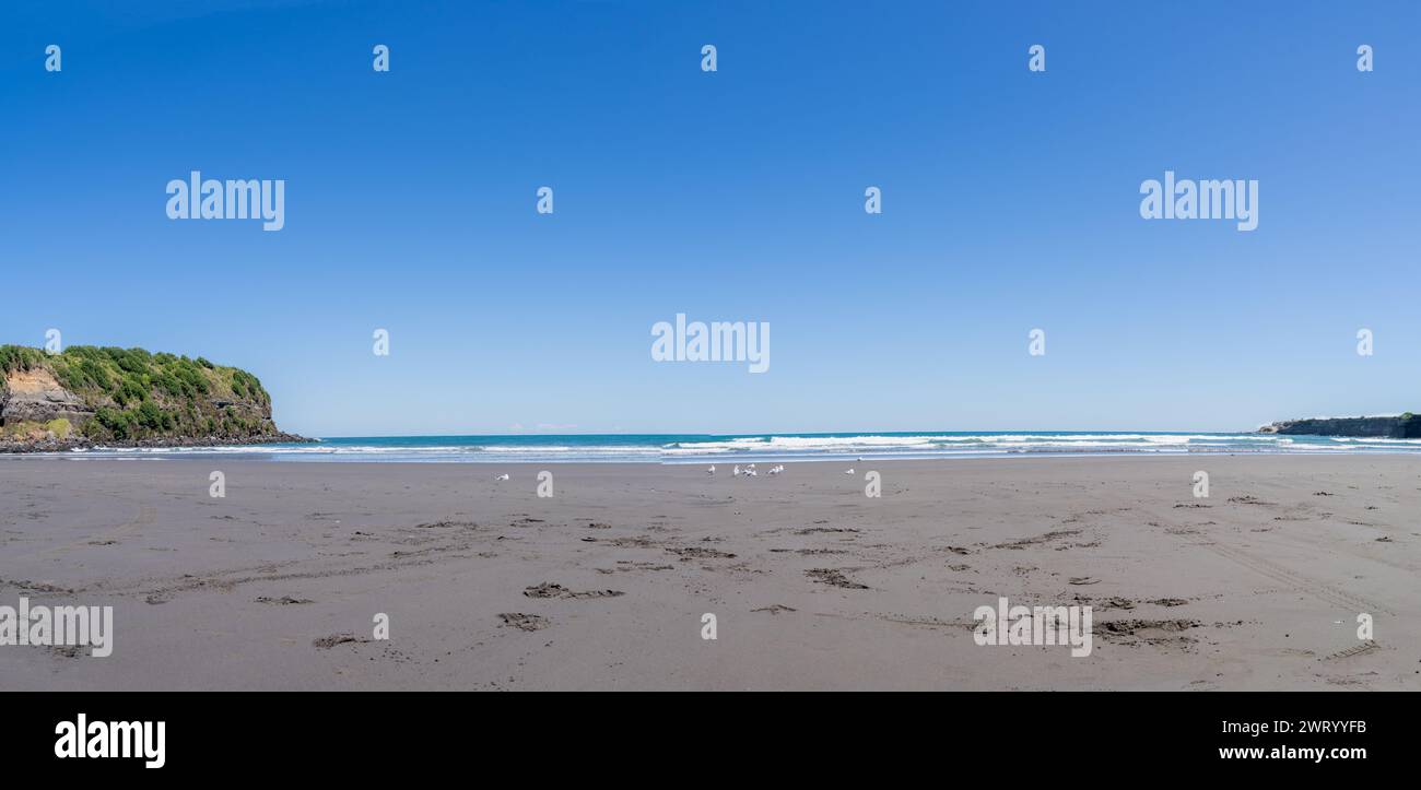 Opunake surf beach with west coast black sand, blue sky and water Stock ...