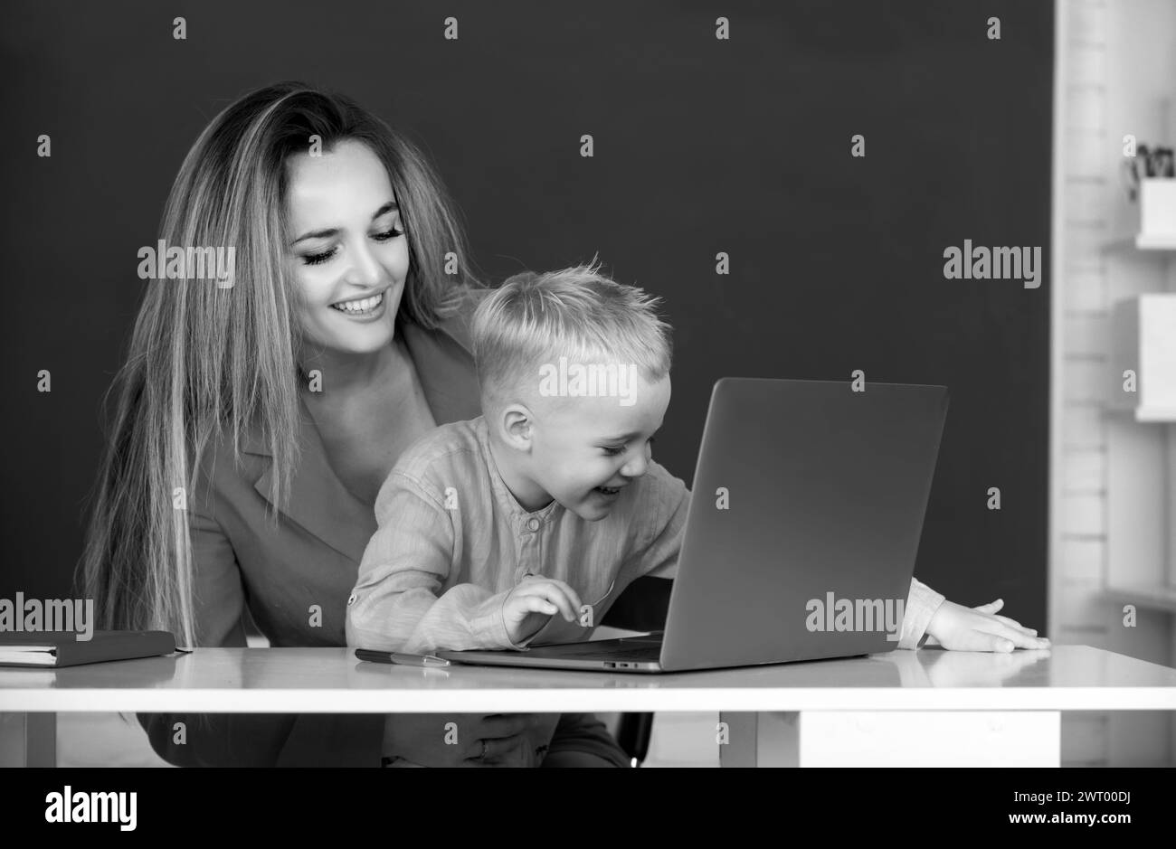 Mother and son together using computer laptop. Little school child son ...