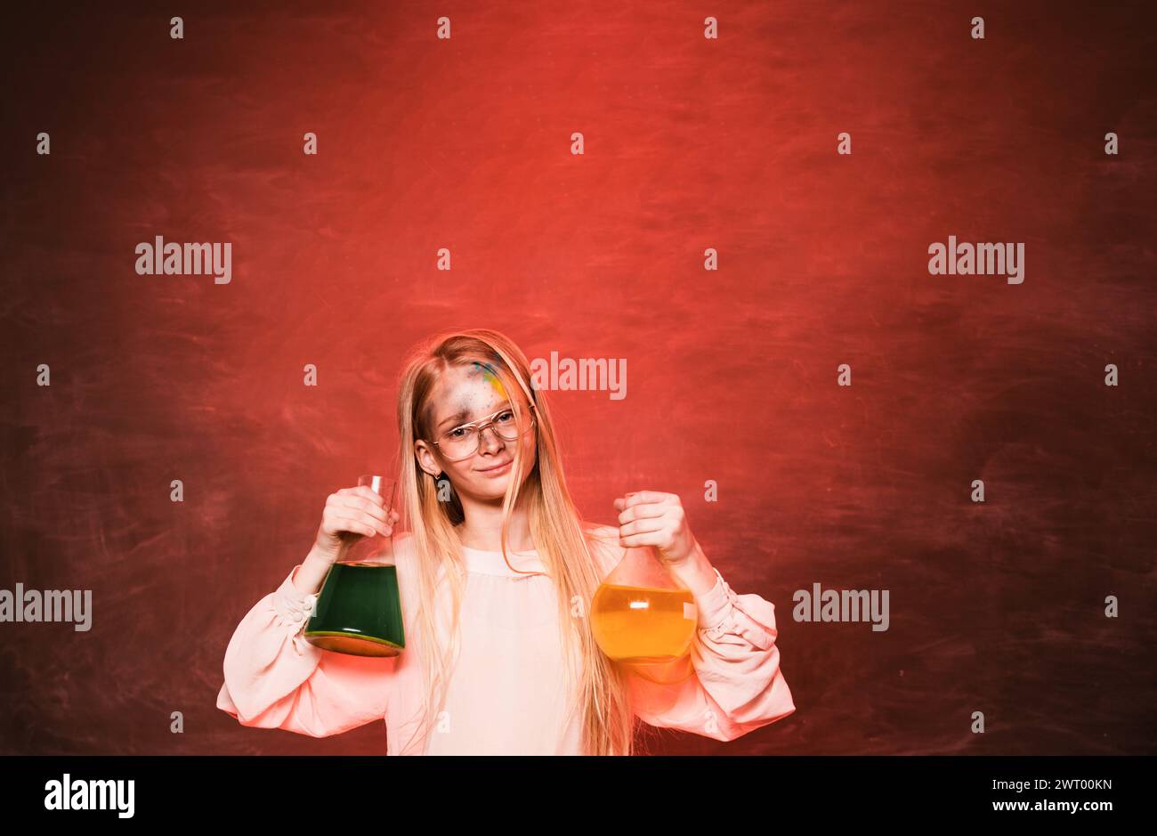 Pretty little girl learning chemistry isolated at red background. Young ...