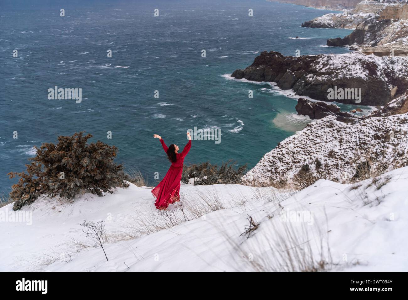 Woman red dress snow sea. Happy woman in a red dress in the snowy ...