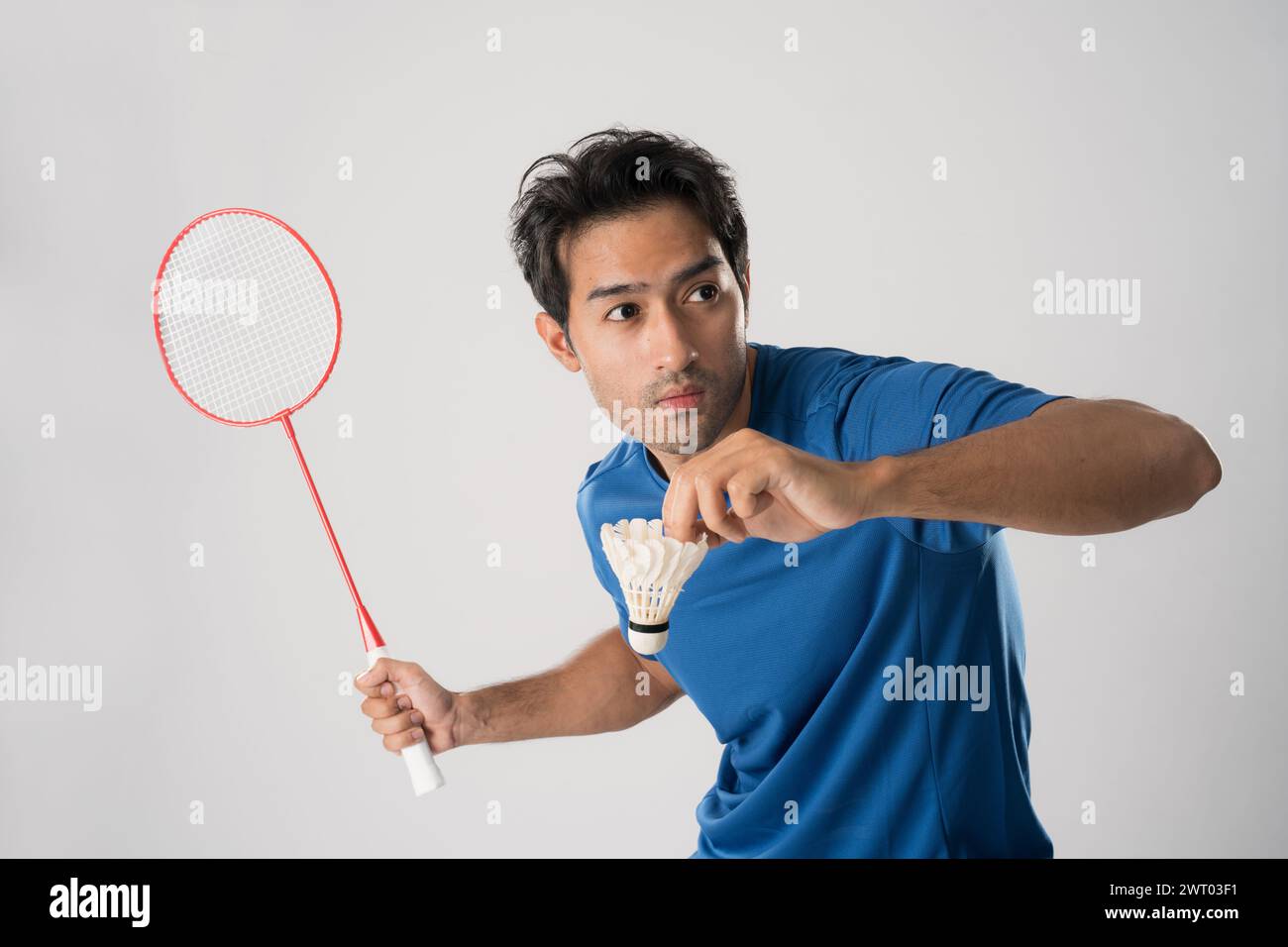 A badminton player in sportswear stands holding a racket and ...