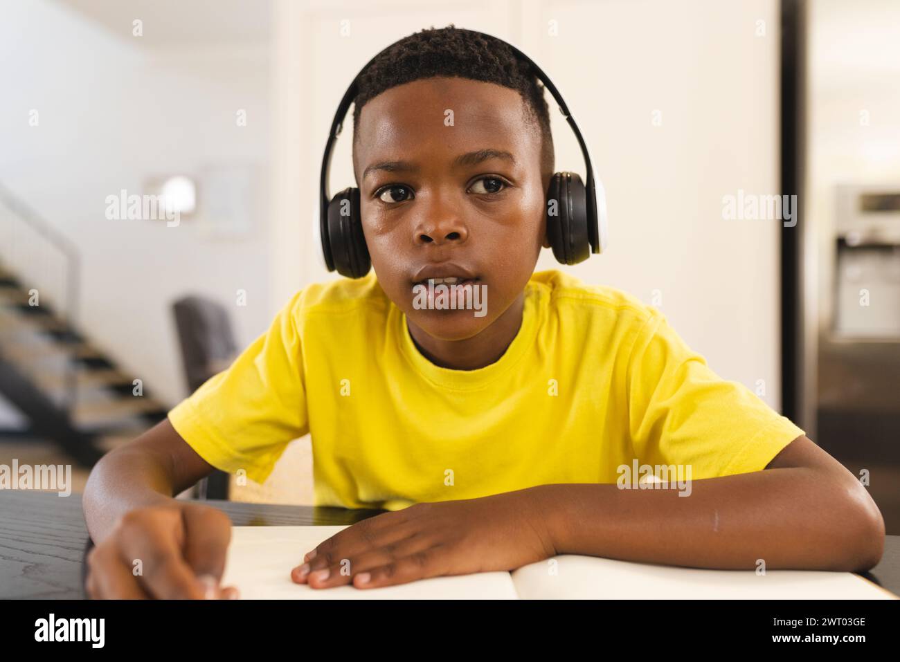 A young African American boy is focused on his homework during an ...