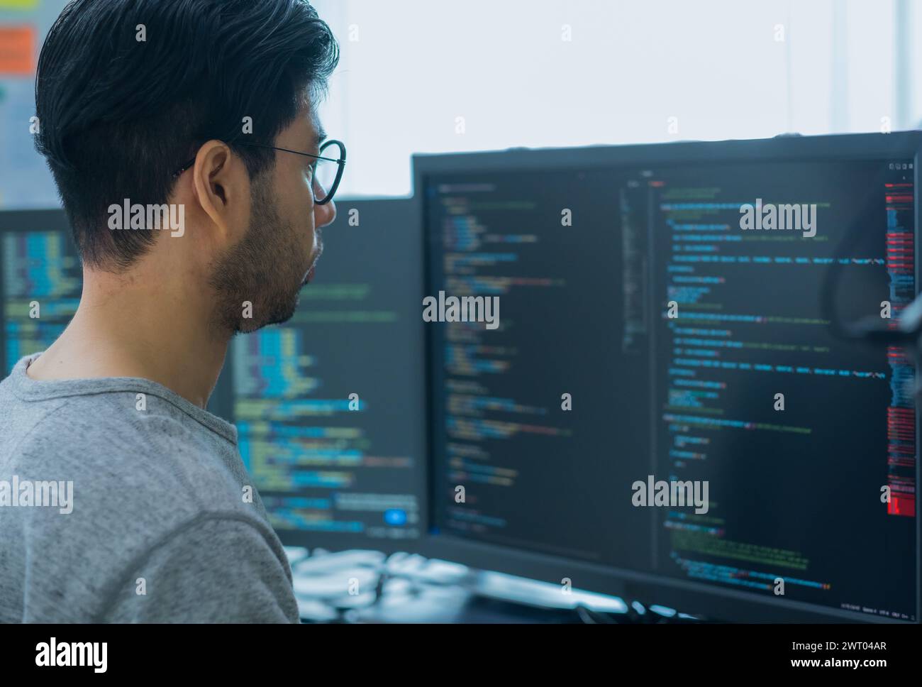 Asian Prompt Engineer Developer Coding App With Software Data Sitting In Front Of Computer