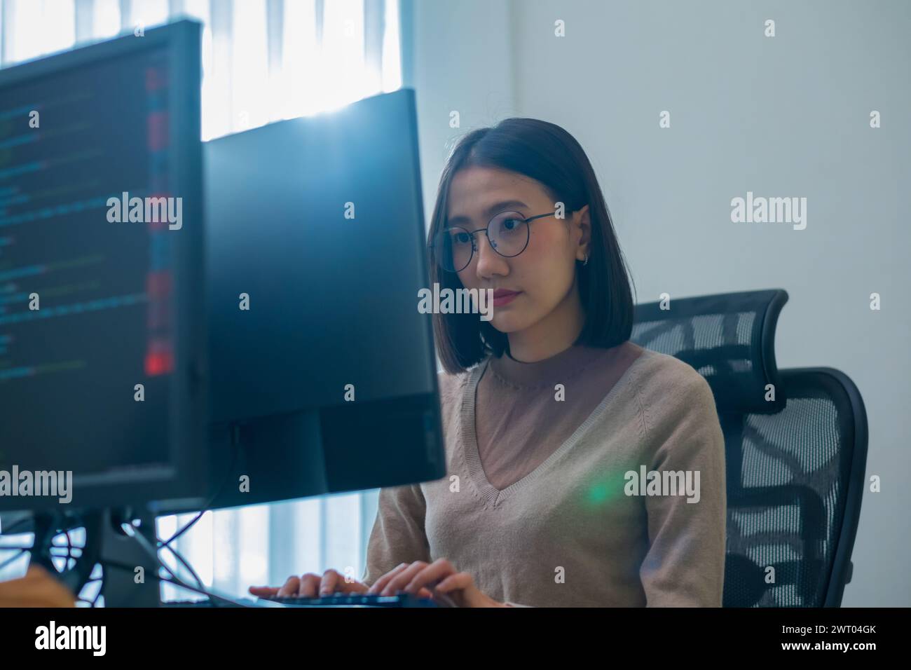 Asian Prompt Engineer Developer Coding App With Software Data Sitting In Front Of Computer