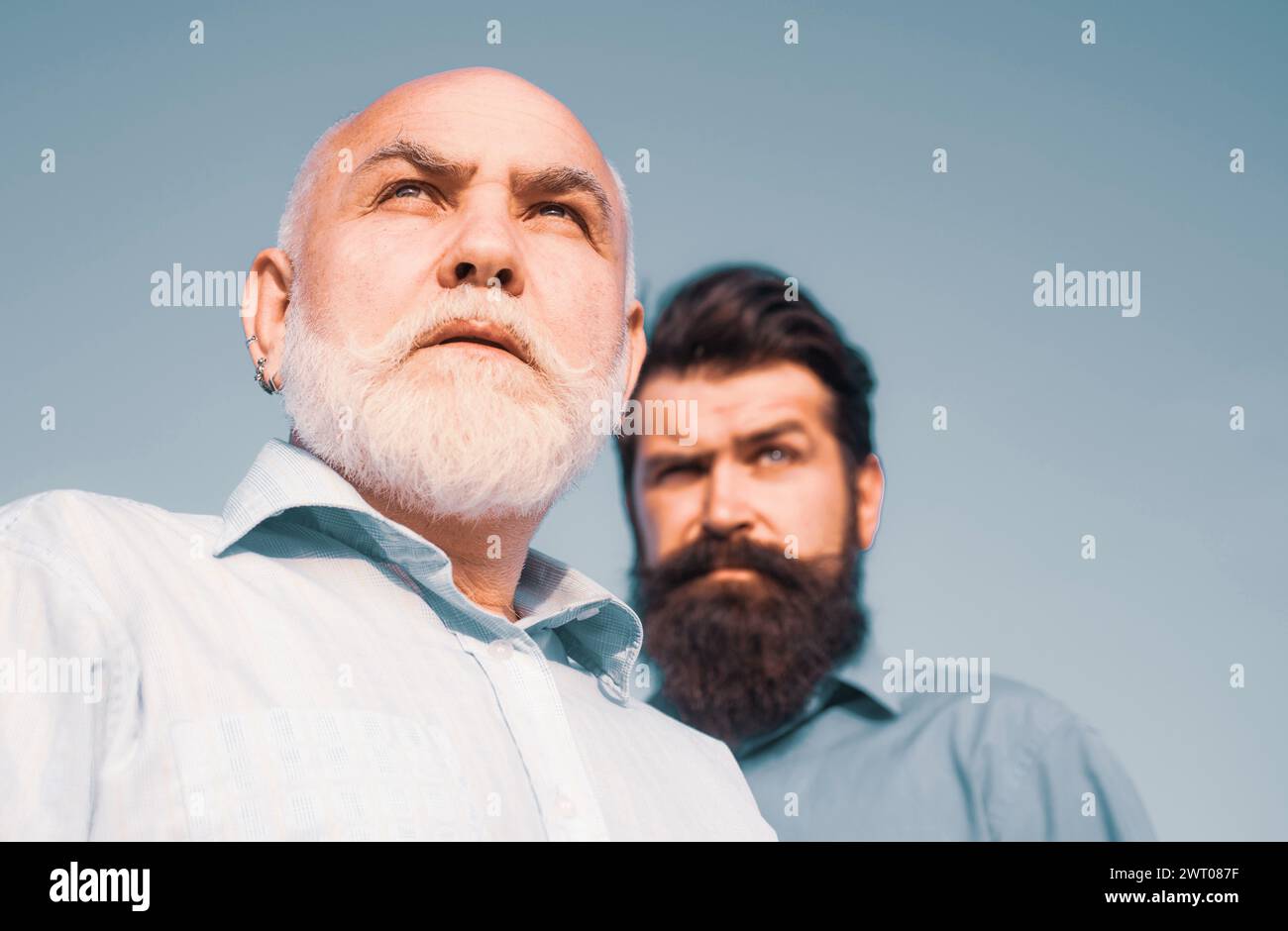 Happy grandfather and father over blue sky and clouds background ...