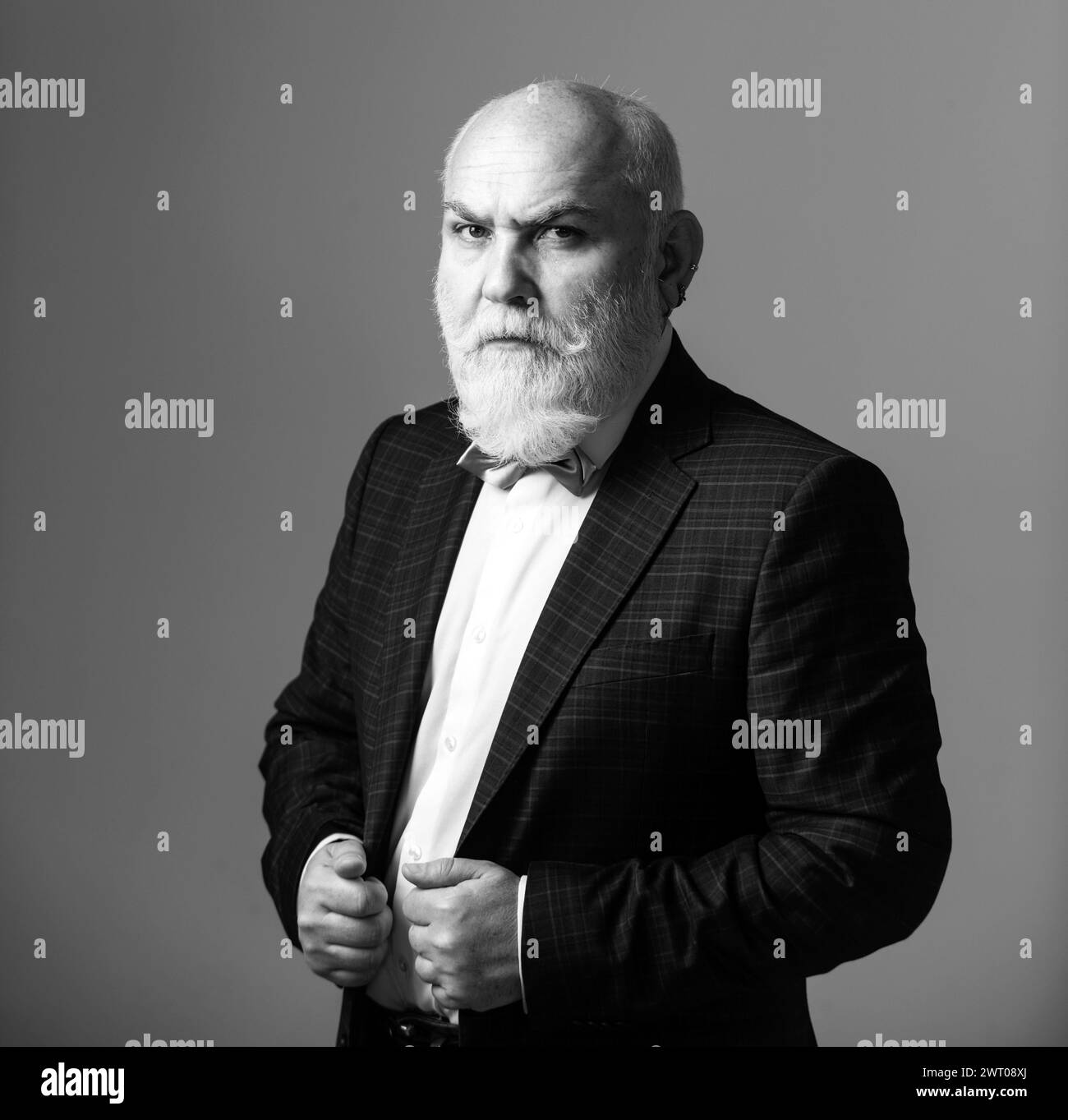 Serious Senior. Confident senior bearded man in a suit and tie stand on ...