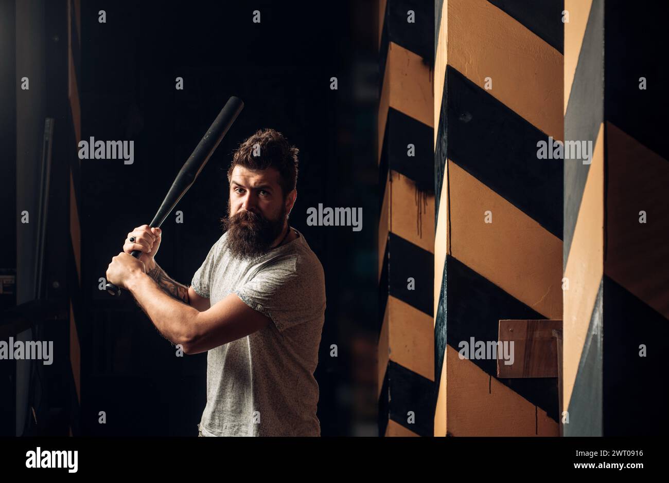 Angry man in t-shirt. Ready to swing. Gangster with bat weapon. Bearded ...