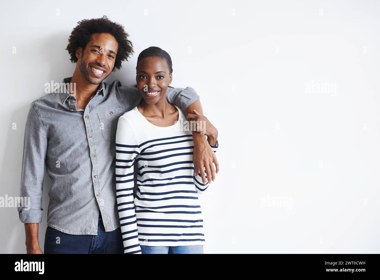 Couple, happiness and portrait by white wall with hug for romance, support and healthy ...