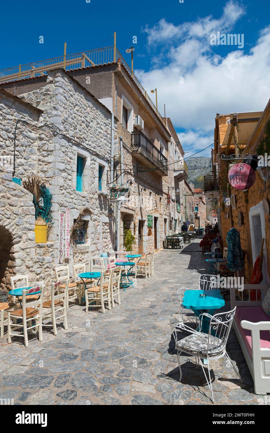 A sunny alleyway view with cafes and traditional stone buildings under ...