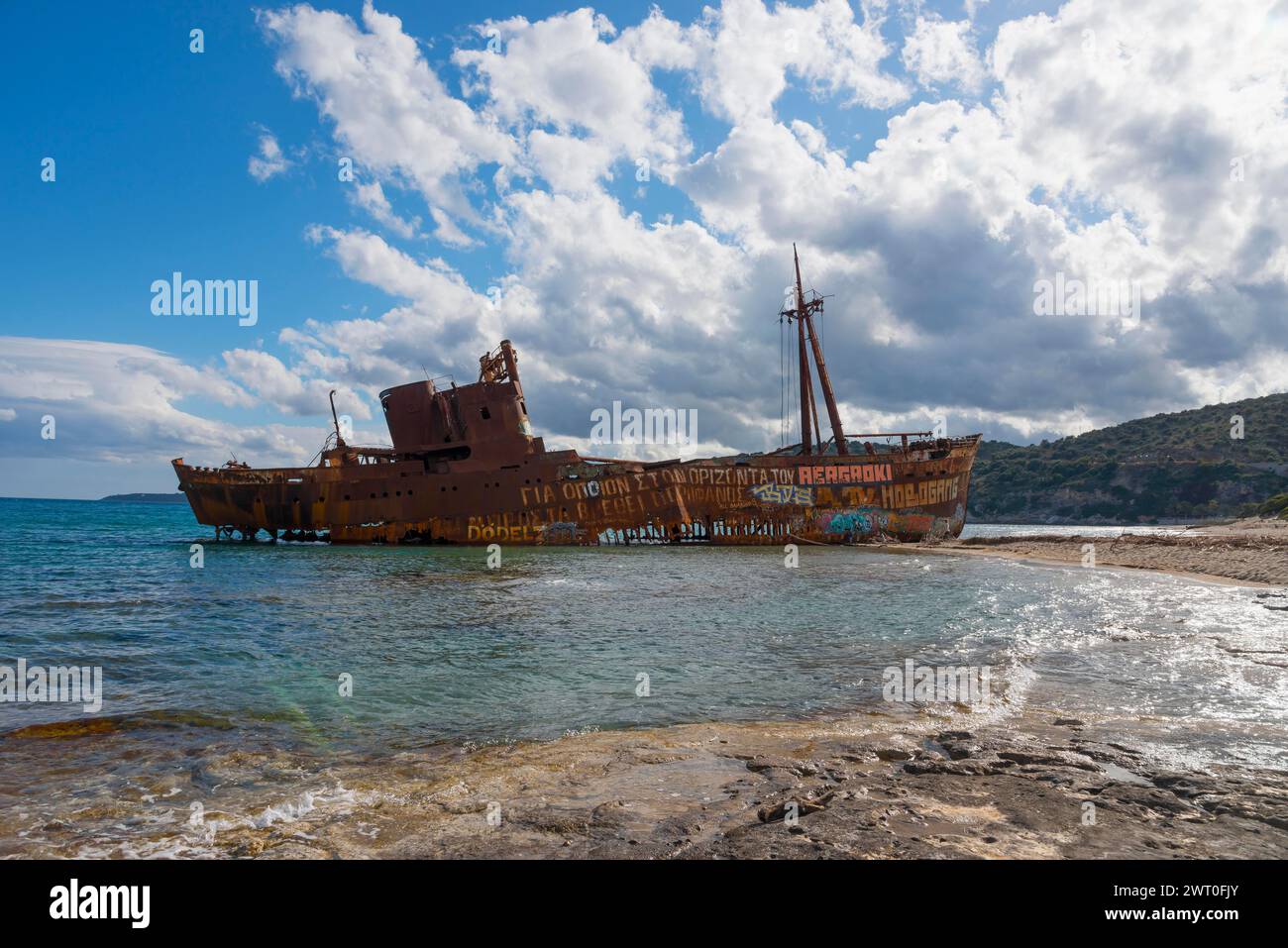 Rusty shipwreck on a sunny beach with blue sky and clouds, Shipwreck ...