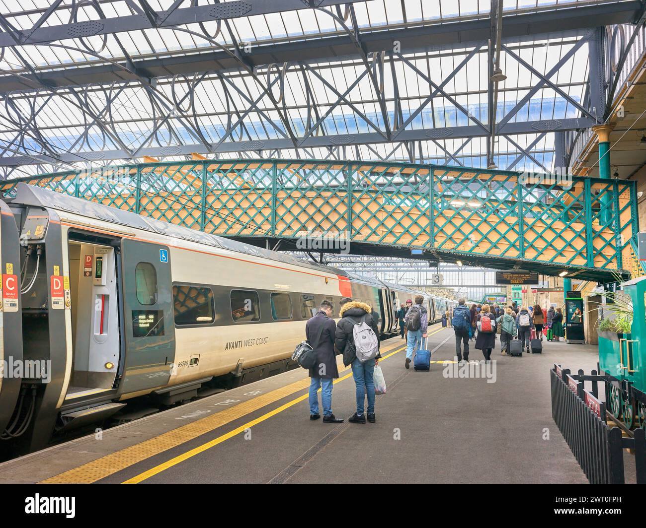 Passengers wait for a train on a platform at the railway station in Carlisle, England Stock ...
