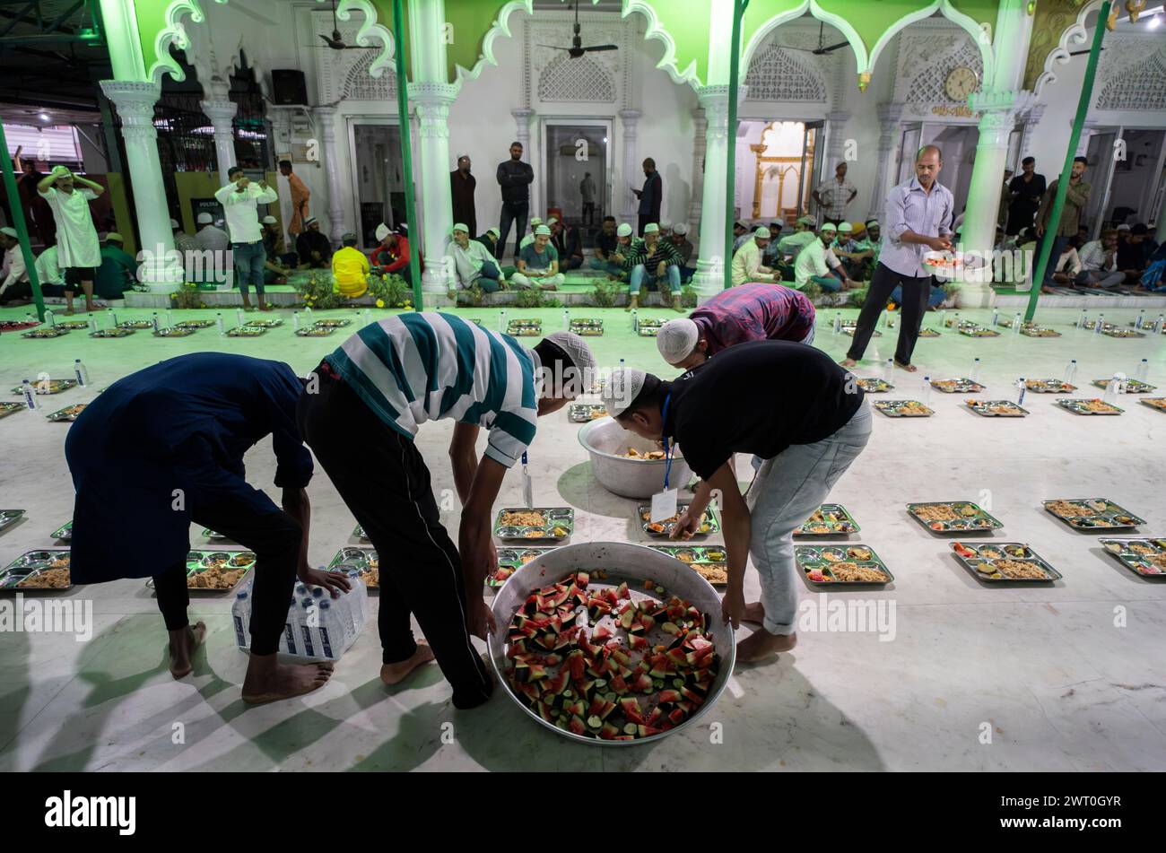 Volunteers distribute and arrange rows of 'iftar' meal for devotees to ...