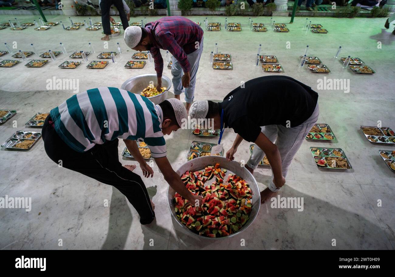Volunteers distribute and arrange rows of 'iftar' meal for devotees to ...