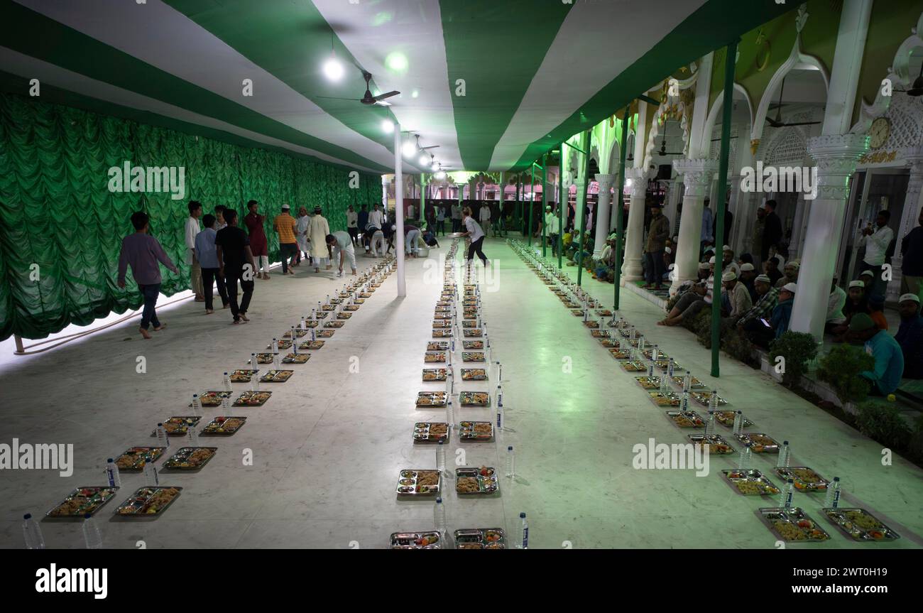Volunteers distribute and arrange rows of 'iftar' meal for devotees to ...