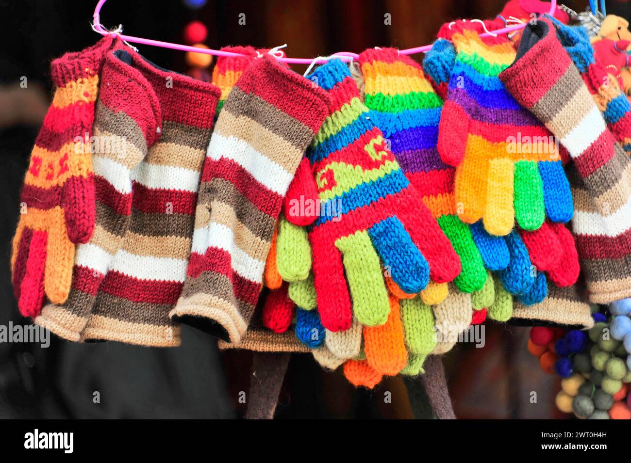 Colourful selection of knitted woollen gloves on a market stall ...