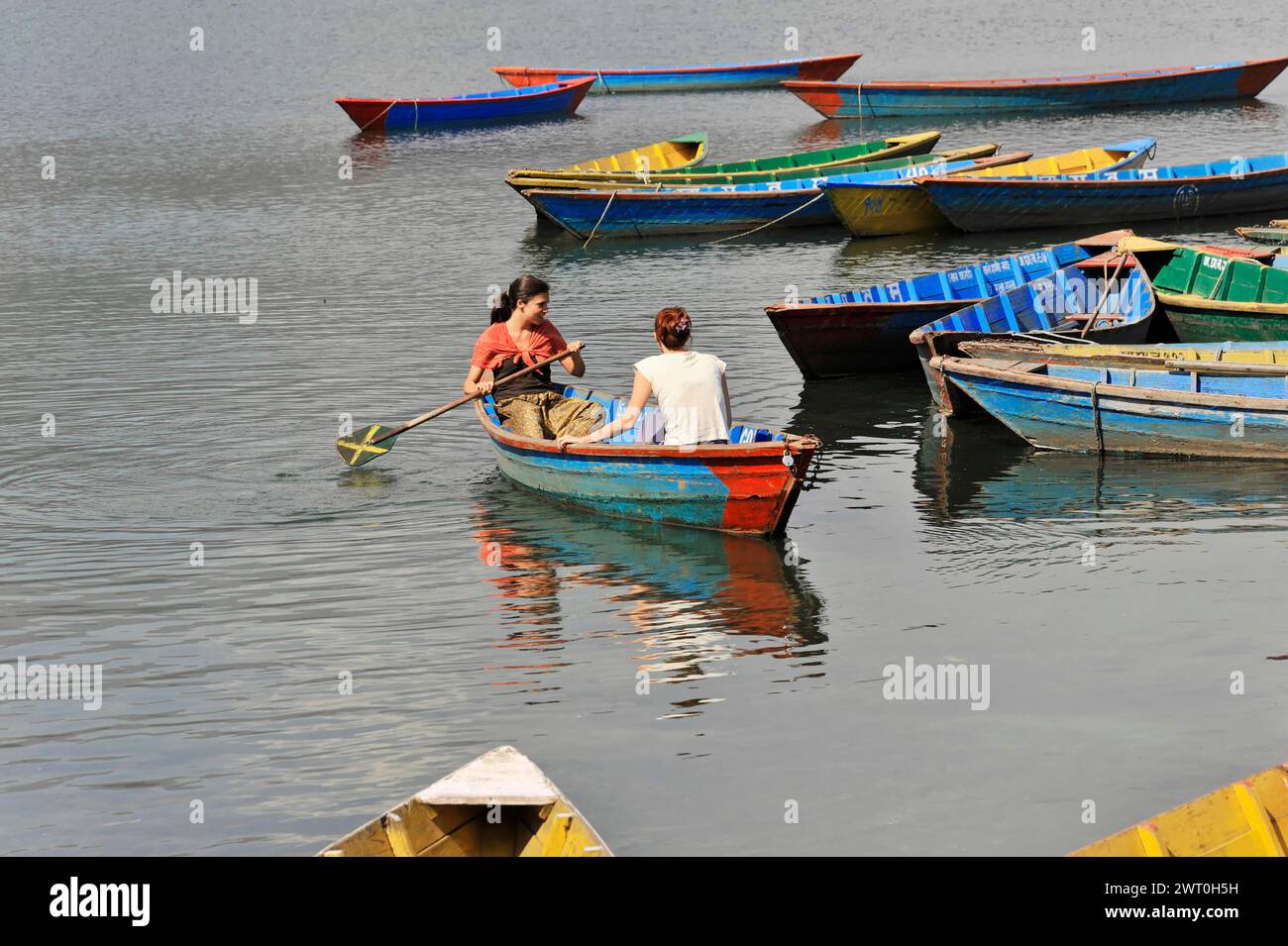 A couple rowing together in a blue boat on a lake, Lake Pehwa, Pokhara ...