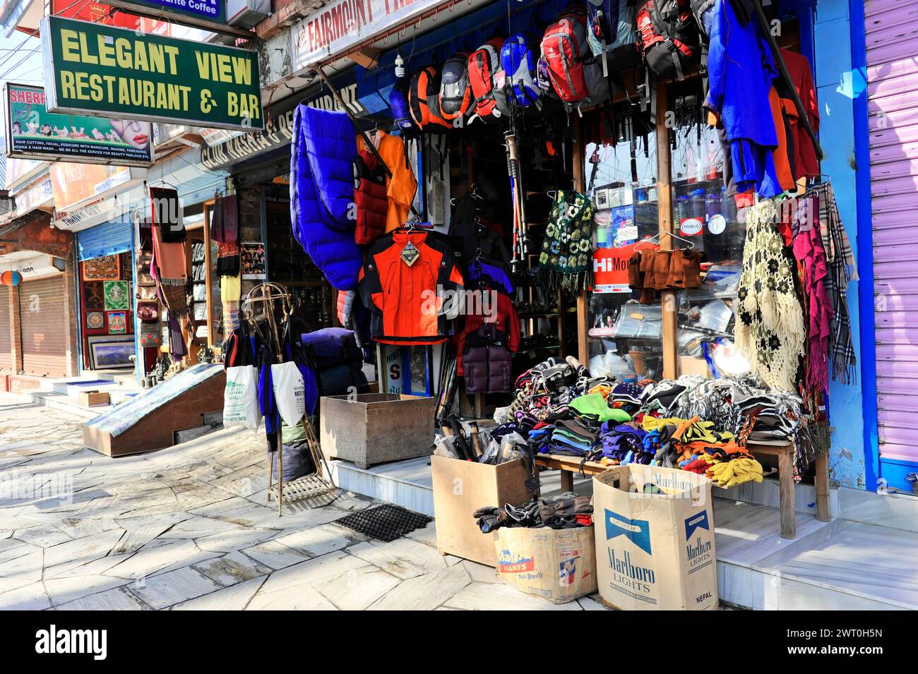 Exterior view of a clothing shop with various colourful textiles for ...