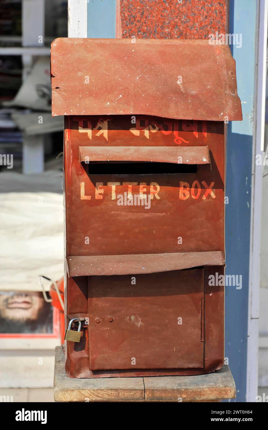 Old traditional red letterbox on a wall with visible signs of use ...