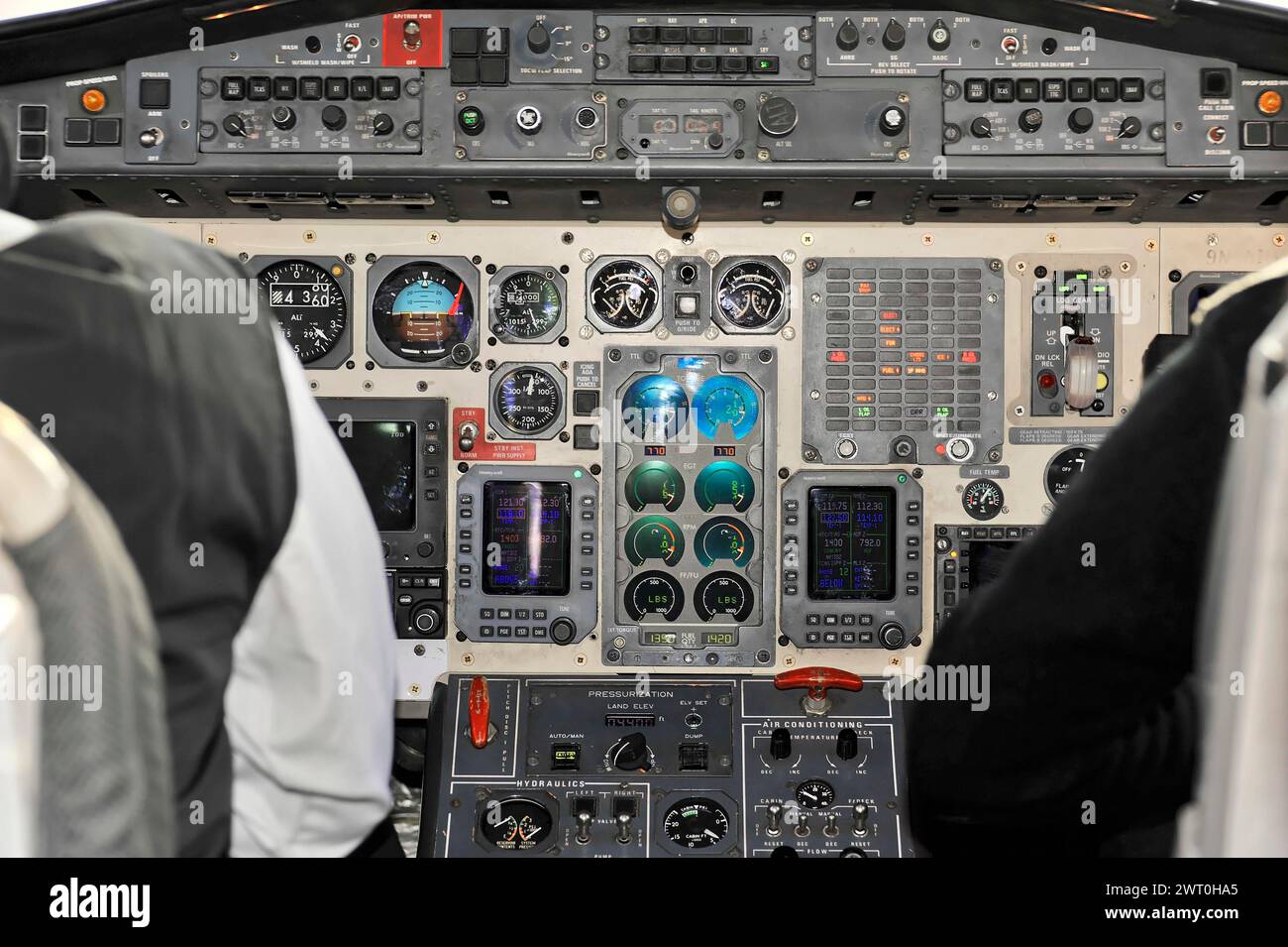 Close-up of a cockpit instrument panel with switches and screens ...