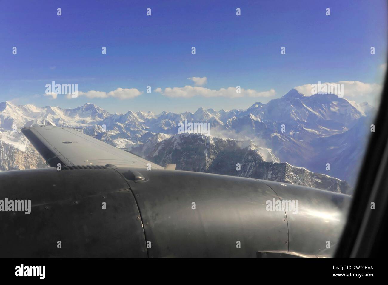 View through an aeroplane window of snow-covered mountain ranges ...