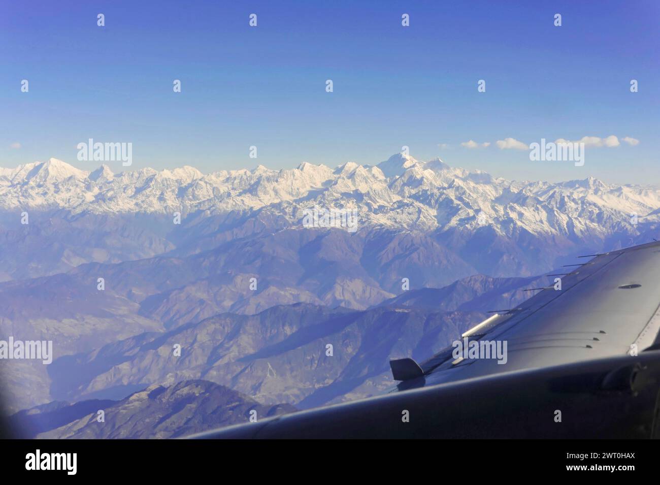 View of snow-covered mountains and the aeroplane wing in the foreground ...