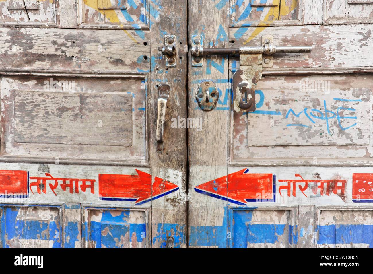 Worn wooden doors with coloured signposts and Nepalese writing ...