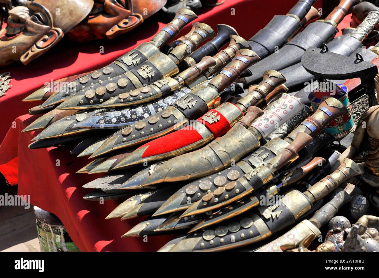 Various traditional daggers with decorative metal elements on a market ...