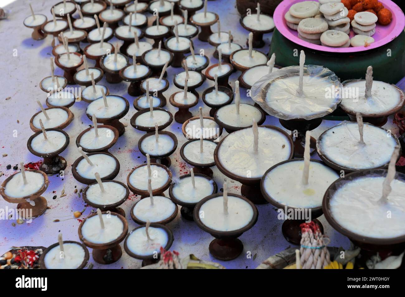 Many small candles in clay pots, apparently for a religious ritual ...