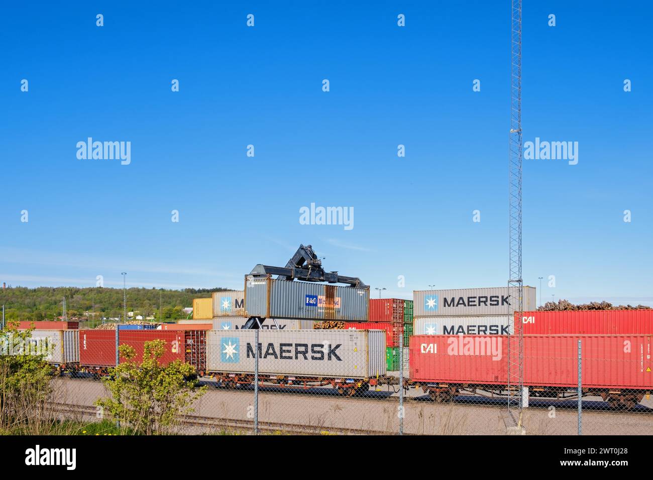 Machine Crane loading containers onto railway wagons at a loading area ...