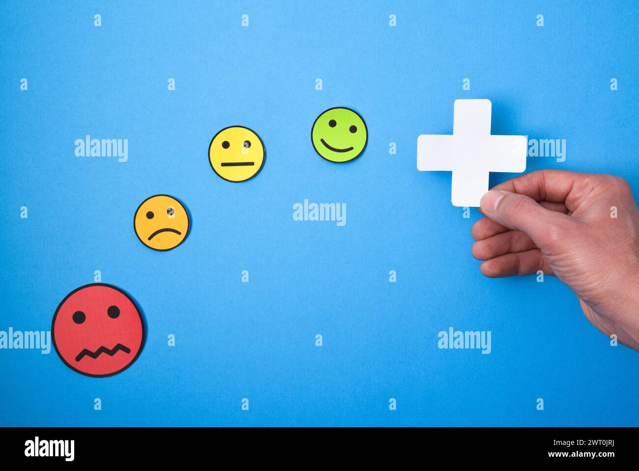 Conceptual health scheme with paper cut out emoticons and hand showing ...