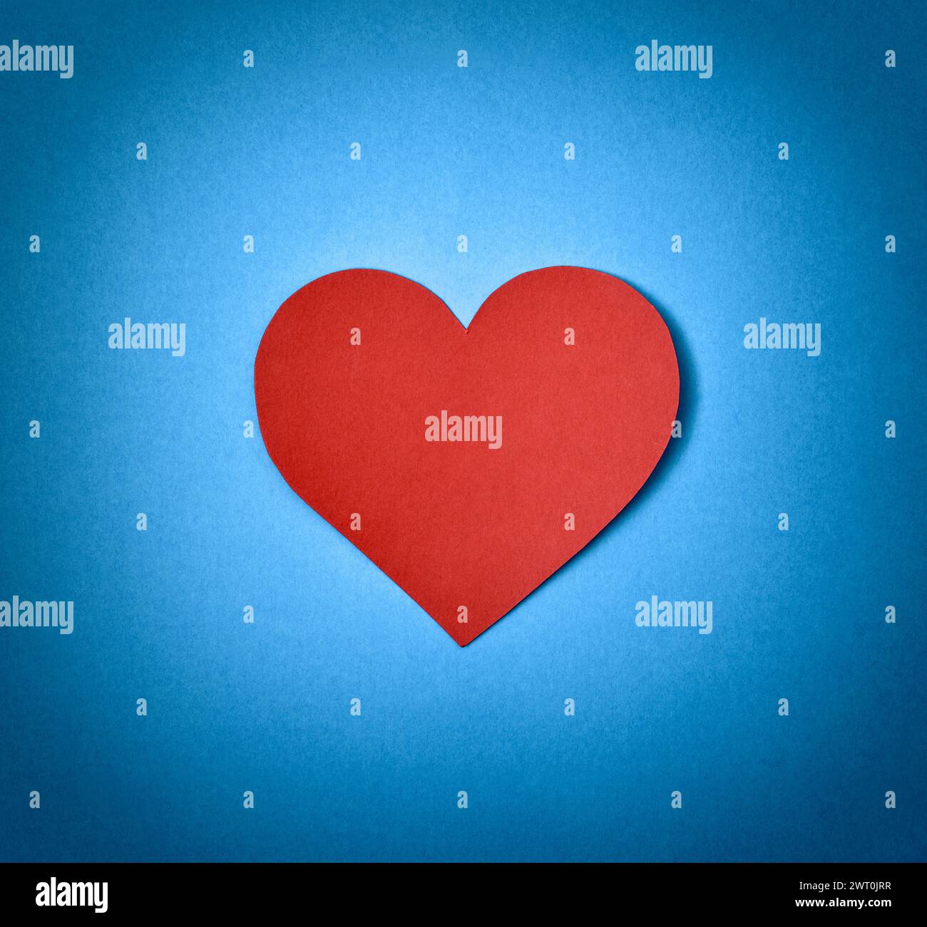 Cut out paper red heart background isolated on textured blue background ...