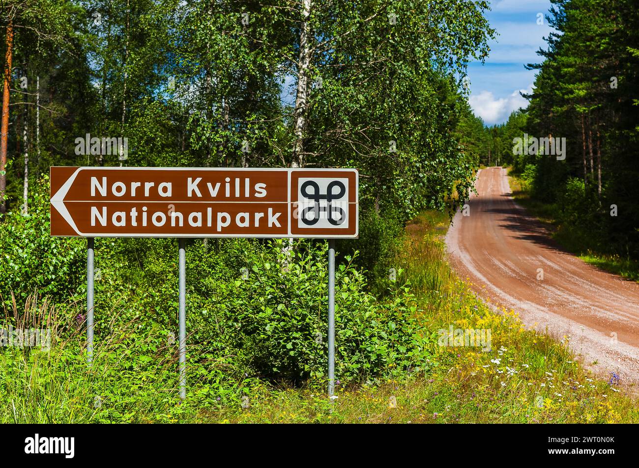 A road sign is visible on the side of a dirt road, indicating ...