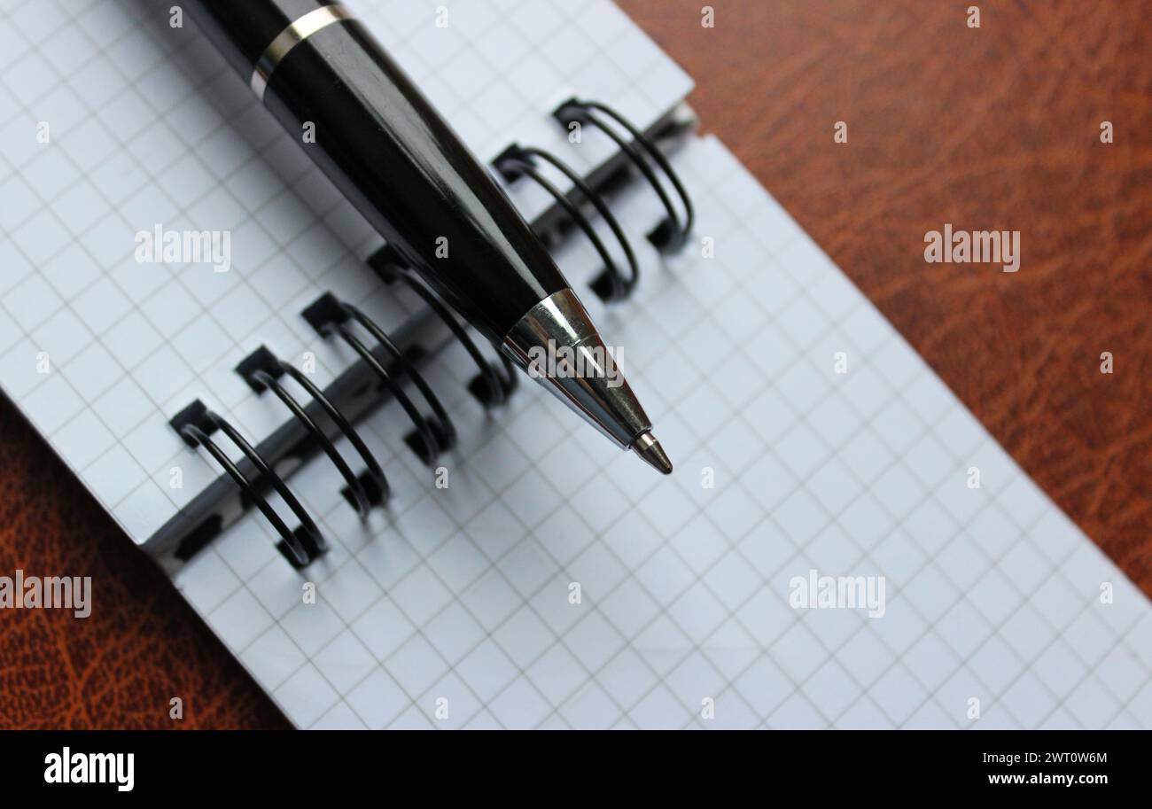 Business Pen On A Binder Of Checkered Note On A Leather Folder Stock ...