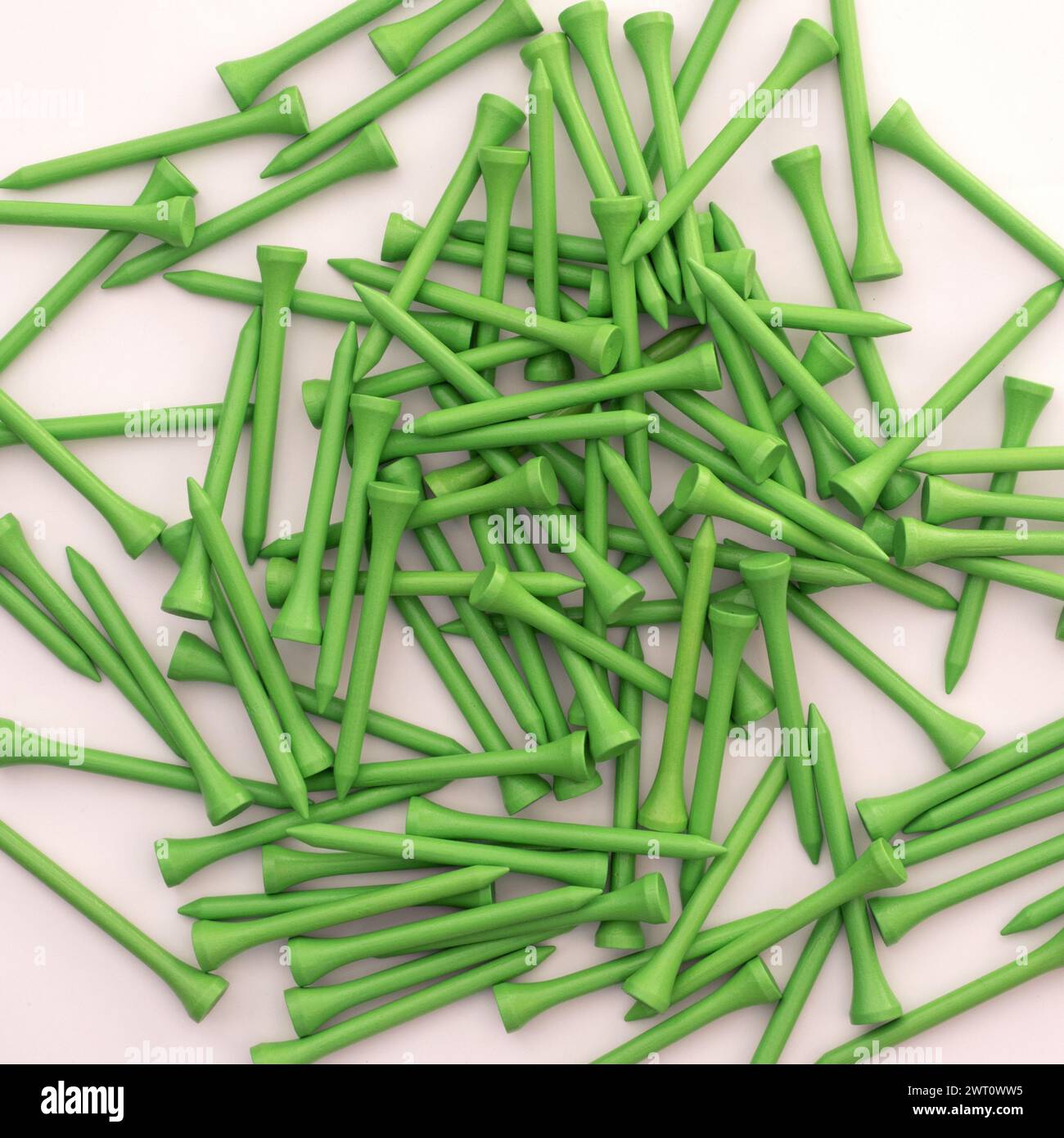 A pile of green wooden golf tees on a white background Stock Photo - Alamy