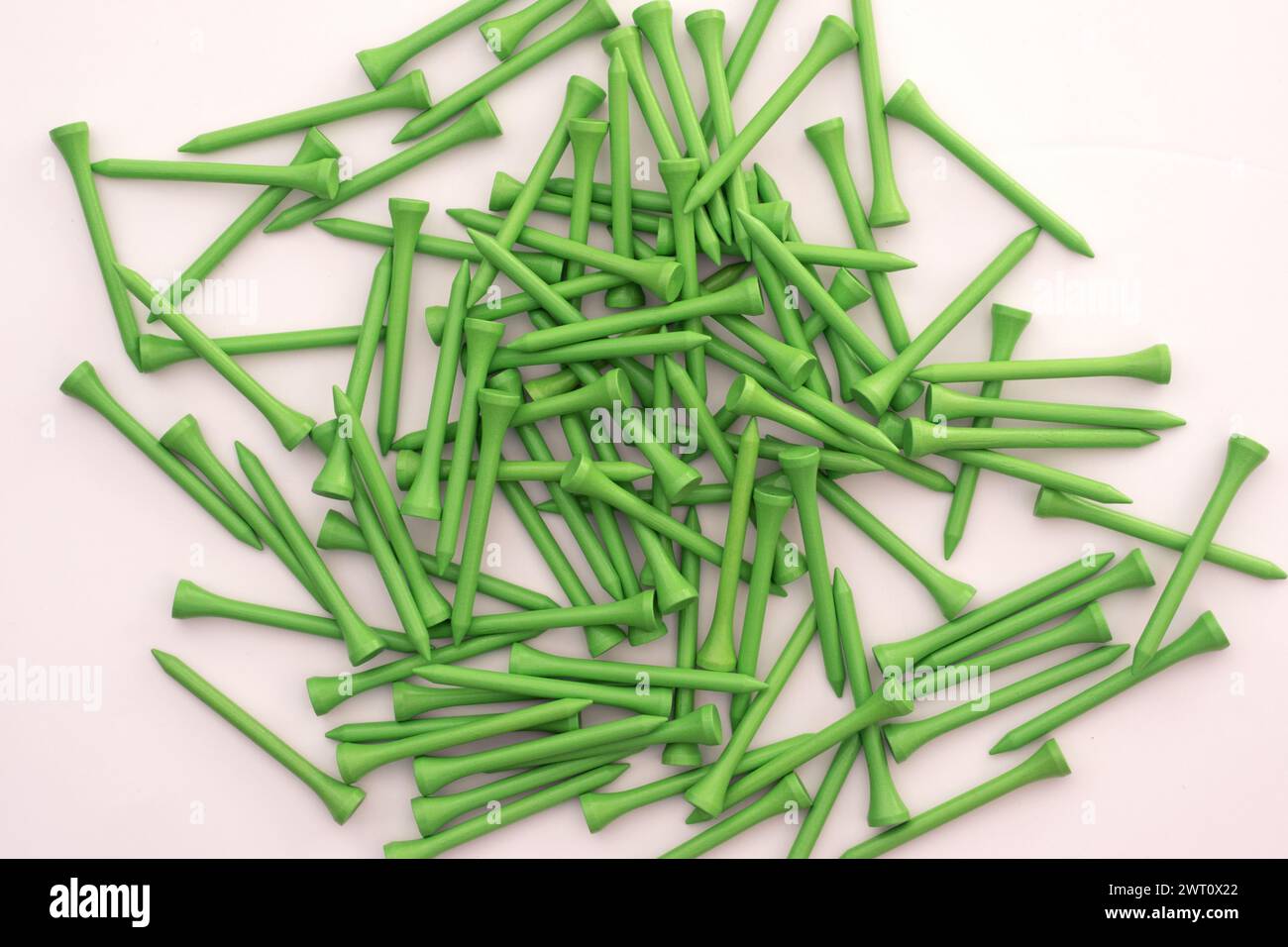 A pile of green wooden golf tees on a white background Stock Photo - Alamy