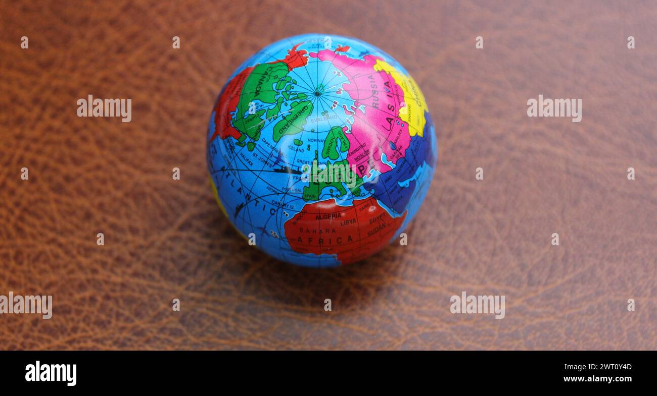 Miniature globe on a leather surface with conventionally drawn ...