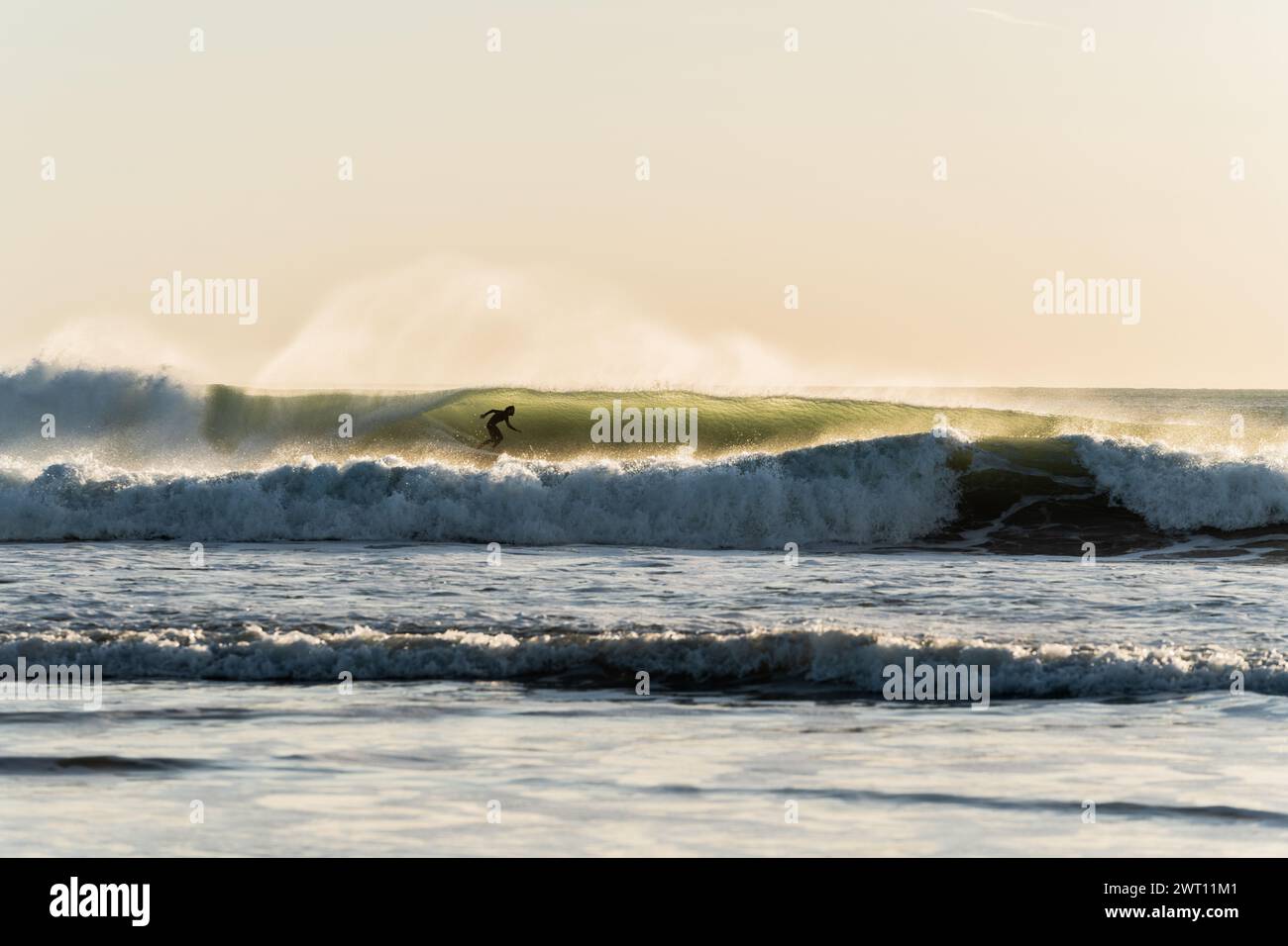 person inside the tube in the wave on the sea shore, high contrast ...