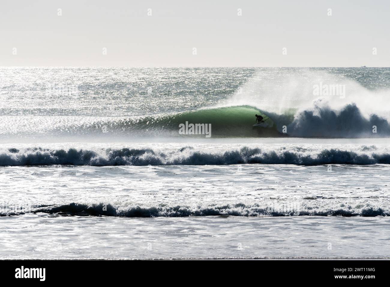 person inside the tube in the wave on the sea shore, high contrast ...