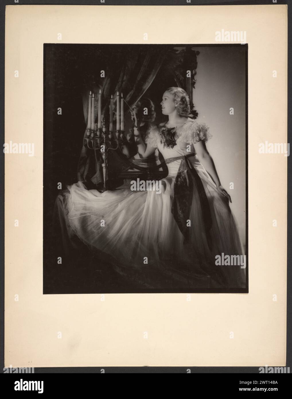 Woman lighting candelabra. Günther Krampf, photographer (Austrian, 1899 - 1950) 1930s Portrait ...