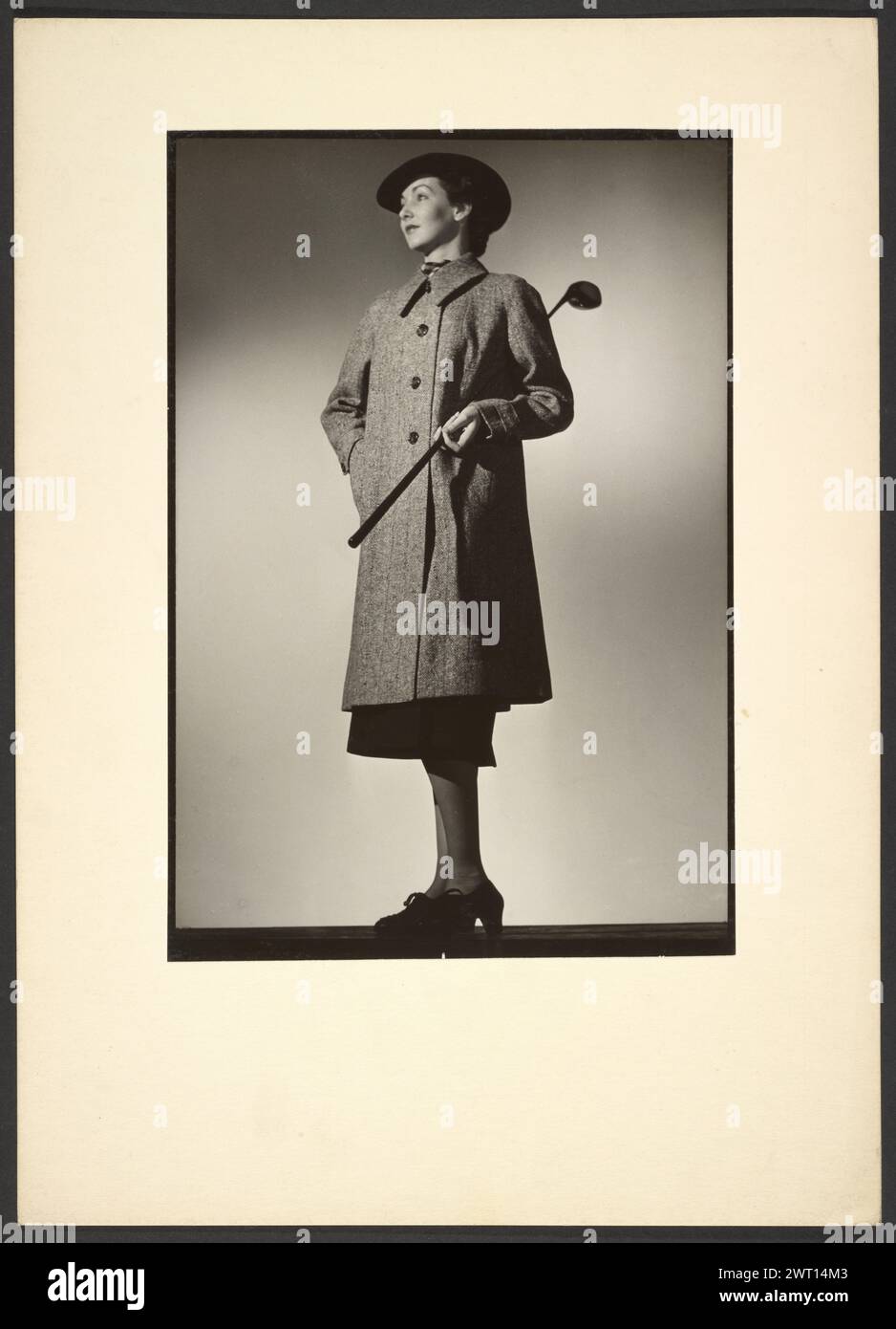 Woman modeling coat with golf club. Günther Krampf, photographer (Austrian, 1899 - 1950) early ...
