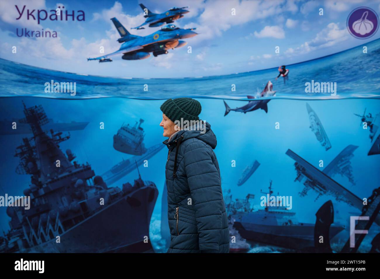 A woman walks by a poster of a Ukrainian postal stamp showing sunken ...