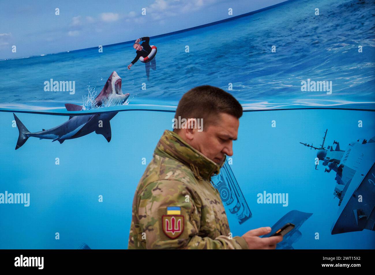 A Ukrainian serviceman walks by a poster of a Ukrainian postal stamp ...