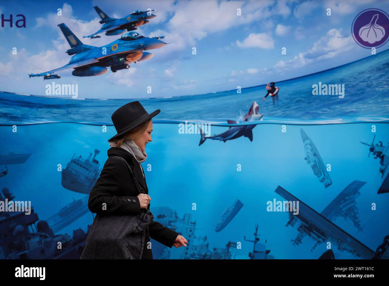A woman walks by a poster of a Ukrainian postal stamp showing sunken ...